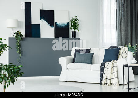 Table with lamp placed at wall with curtains in spacious light modern ...