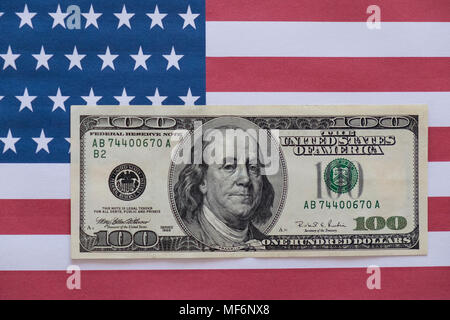 American flag on 100 US dollar bill piles lay on white studio ...