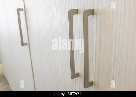 Silver handles on a modern fitted wardrobe Stock Photo - Alamy
