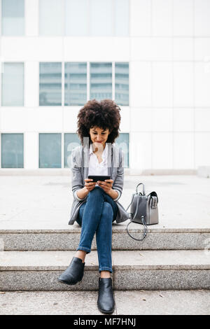 Smiling casual woman with backpack using mobile phone iPhone standing ...
