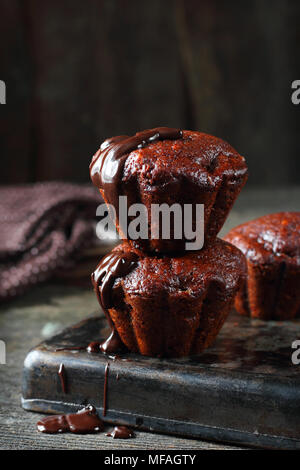 A closeup shot of a homemade baked cupcake placed on a black reflective ...