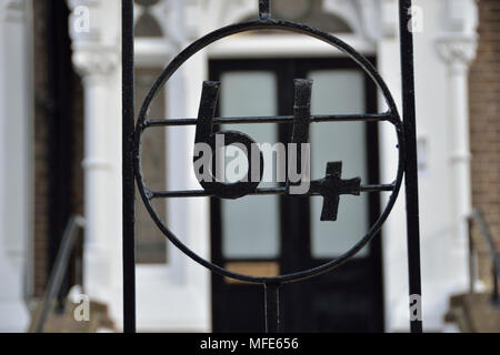 House number 64 with the sixty four in bold brass digits on a black ...