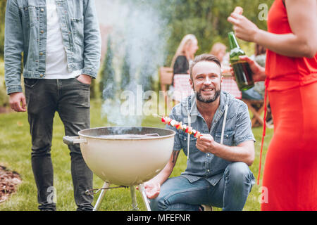 Man squatting and smoking Stock Photo - Alamy