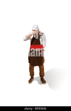Serious butcher posing with a laptop isolated on white background Stock ...