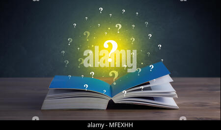Yellow question marks hovering over open book Stock Photo - Alamy