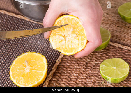 Slicing zested lemon with knife on a table as a background Stock Photo ...