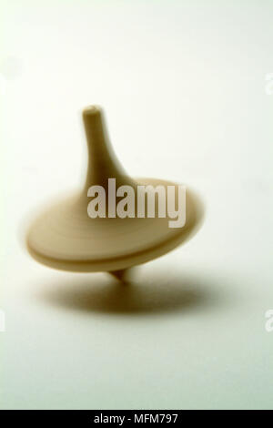 Child's toy top that spins on a rail displayed against a white ...