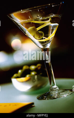 Martini cocktail with olives and lemon twist on dark background Stock ...
