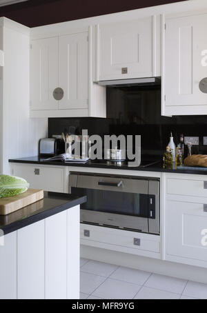 A modern kitchen, black units with integral ovens, storage boxes ...