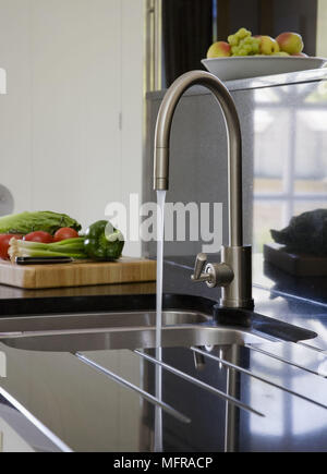 Water running from the modern styled faucet in the sink Stock Photo - Alamy