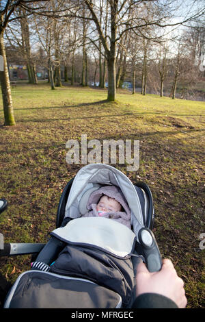 Baby being pushed in a pram / push chair being pushed by a small boy ...