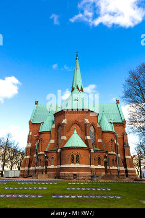 Spring view of red brick gothic church with twin spires framed by fresh ...