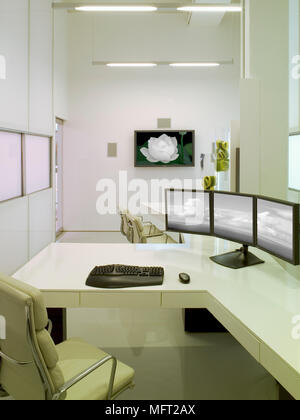 A modern open-plan office featuring rows of desks, ergonomic chairs and ...