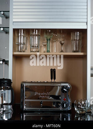 Glass shelving above stainless steel fitted units in modern kitchen ...