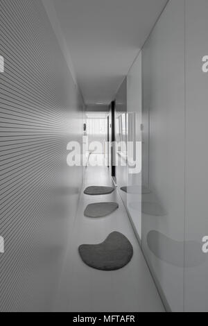 Perspective view of narrow hallway with white walls and wooden floor in ...