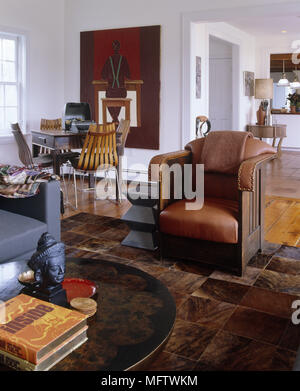 Round dining table and a leather sofa in a cozy living room, focus in ...