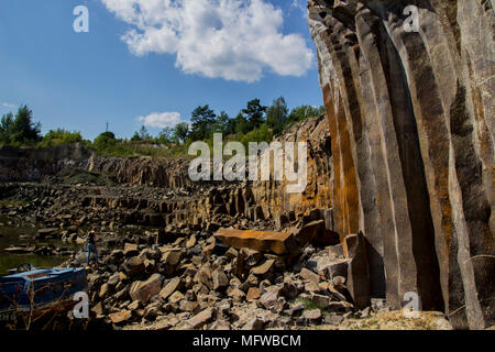 Broken excavator and basalt columns rocks. Heavy industry. Stone ...