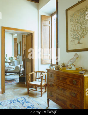 Interior of room with armchair, chest of drawers, folding screen and ...