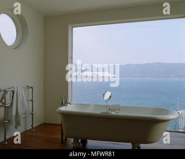 Freestanding bathtub in front of window in country style bathroom Stock ...