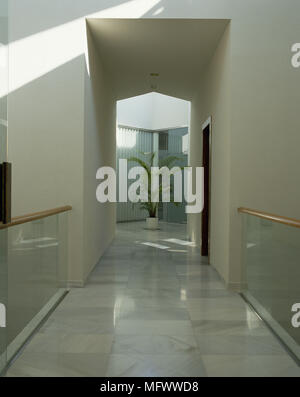 Long narrow corridor with white tiled walls and closed doors of storage ...