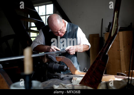 Early American gunsmith in his shop in Colonial Williamsburg Virginia ...