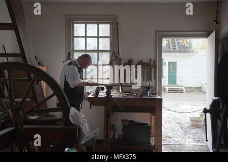 Early American gunsmith in his shop in Colonial Williamsburg Virginia ...