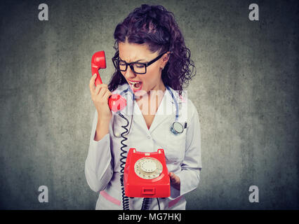 Angry female nurse or doctor screaming with hands on mouth as furious ...