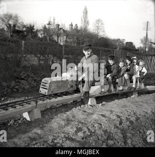 1950s, historical, children riding a train on a miniature railway ...