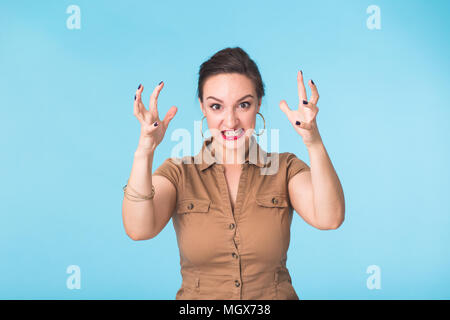Angry aggressive woman with ferocious expression on blue background ...