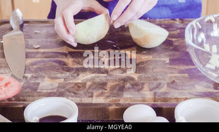 Mincing yellow organic onions on wood cutting board Stock Photo - Alamy