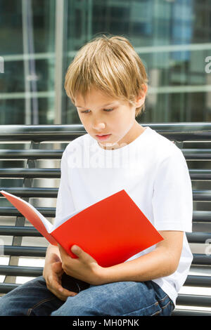 Child flipping through book pages outdoors in the city Stock Photo - Alamy