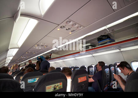 passengers boarding inside easyjet flight as overhead lockers fill up ...