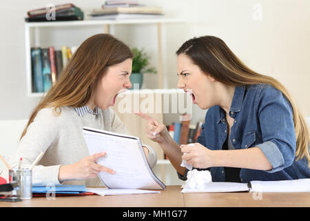 Two angry friends or roommates arguing and threatening in the living ...