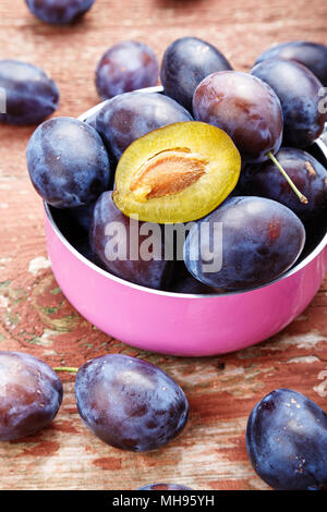 Blue plums in bowl with pink flowers. Summer autumn fruit Stock Photo ...