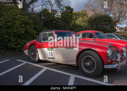 A FRONT OFFSIDE VIEW OF A RED AUSTIN A40 FARINA CLASIC CAR GOING ROUND ...