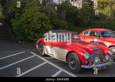 A FRONT OFFSIDE VIEW OF A RED AUSTIN A40 FARINA CLASIC CAR GOING ROUND ...