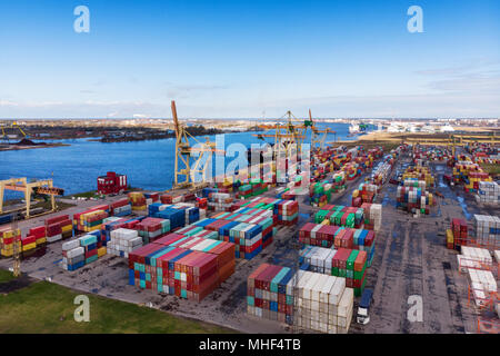 industrial port with containers. Terminal crane loads container on ship ...