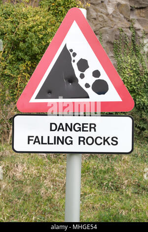 Falling rock danger sign in front of a snow covered mountain on top ...