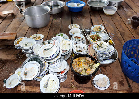 Plate, bowl, spoon. Have not washed. Are stack on wooden board. Food ...