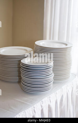 Group of white plates stacked together in a hotel and blurred ...