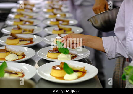 student preparing meals for their graduation guests at a cooking school ...