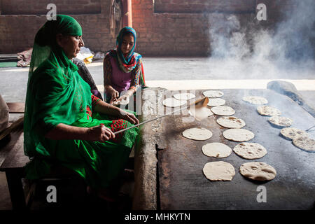 Man and woman making chapatis (Indian bread). The Golden Temple kitchen ...