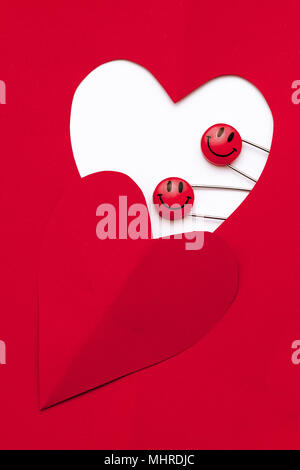 Plastic head metal safety pins pinned in paper. Pink smile emoticon ...