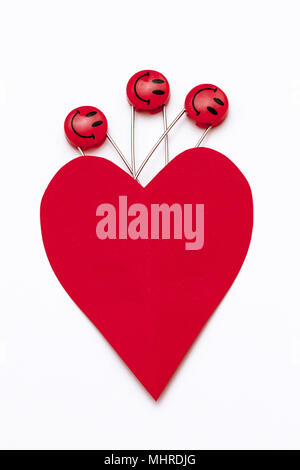 Plastic head metal safety pins pinned in paper. Pink smile emoticon ...