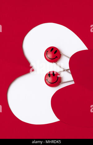 Plastic head metal safety pins pinned in paper. Pink smile emoticon ...