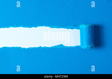 ripped white paper with rolled edges on blue background Stock Photo - Alamy