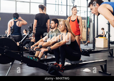 People using rowing machines in gym Stock Photo - Alamy