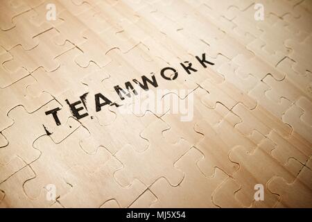 Teamwork word stamped on a wooden puzzle Stock Photo - Alamy
