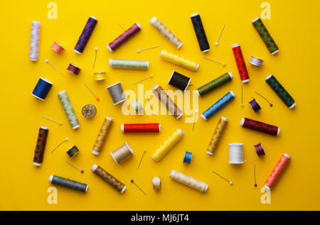 Colorful thread spools disorganized over bright colorful background ...