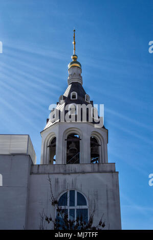 Modern belfry tower of a religious building with roof and cloudy sky ...